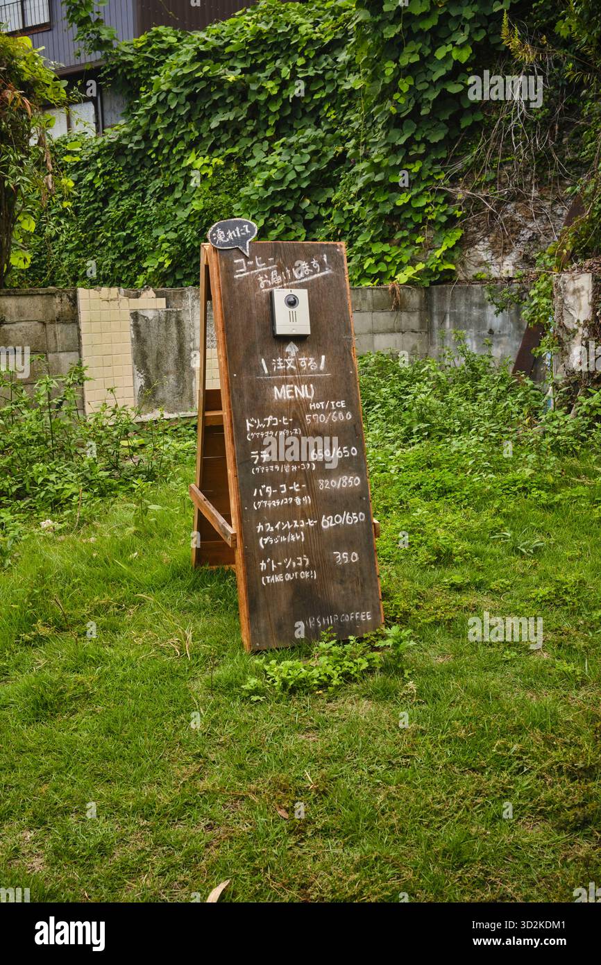 Menu of a coffee shop displayed on a folded wooden stand with a video ...