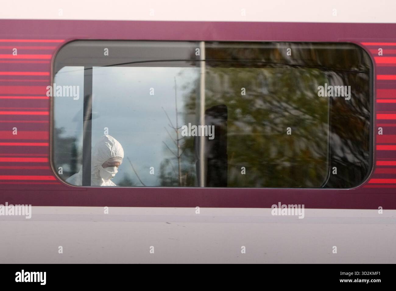 A forensic investigator examines the inside of a train after a mass ...