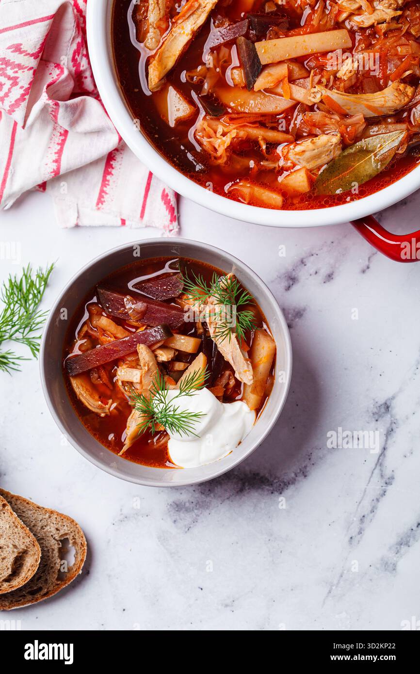 Classic homemade borscht with chicken in a grey bowl on the table, top ...
