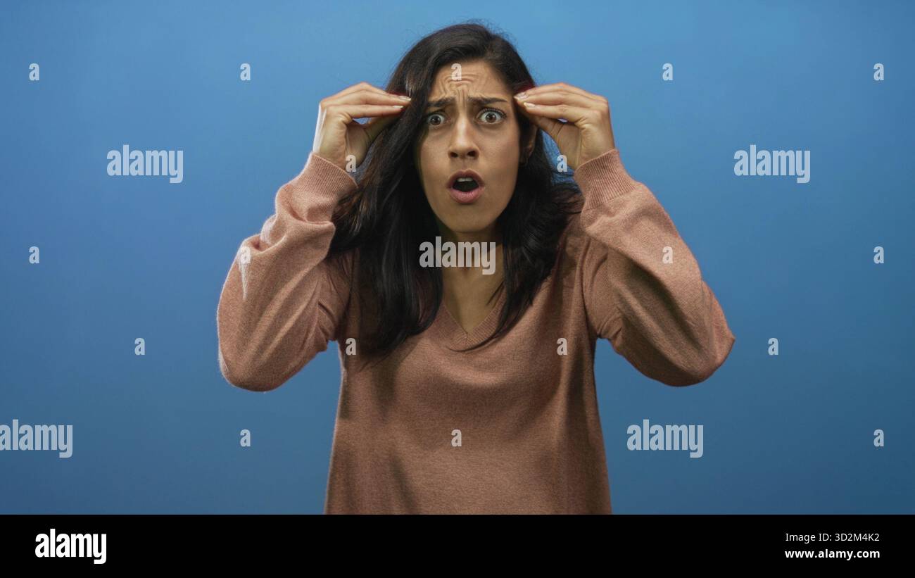 Woman with raised hands and furrowed brow showing open mouth and face ...