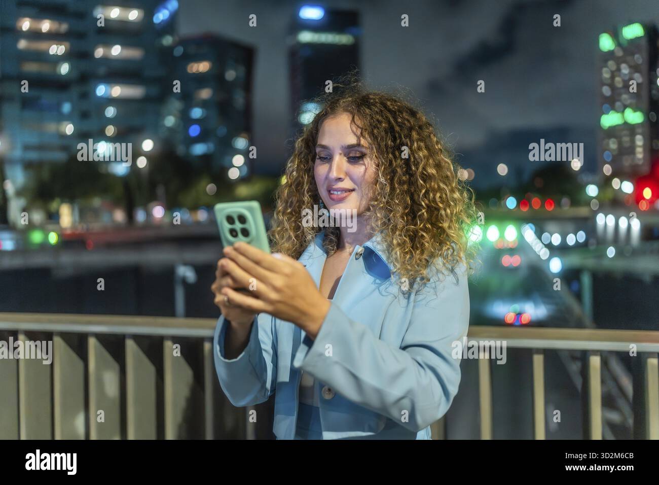Woman scrolling smartphone night street hi-res stock photography and ...