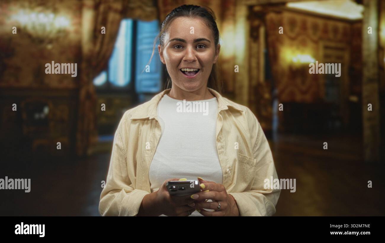 Woman holding smartphone and smiling while reading messages, thumbs ...