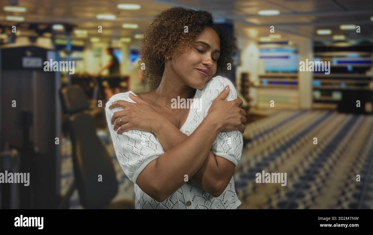 Woman hugging shoulders with arms crossed, eyes closed, visible ...