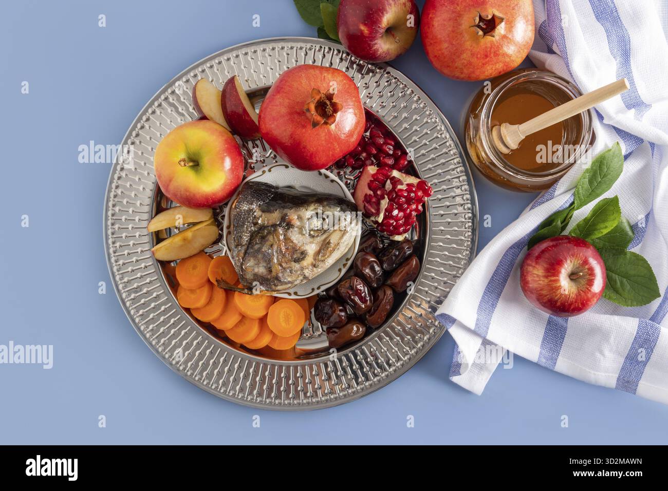 A silver dish with traditional food Rosh Hashanah. pomegranates, apples ...
