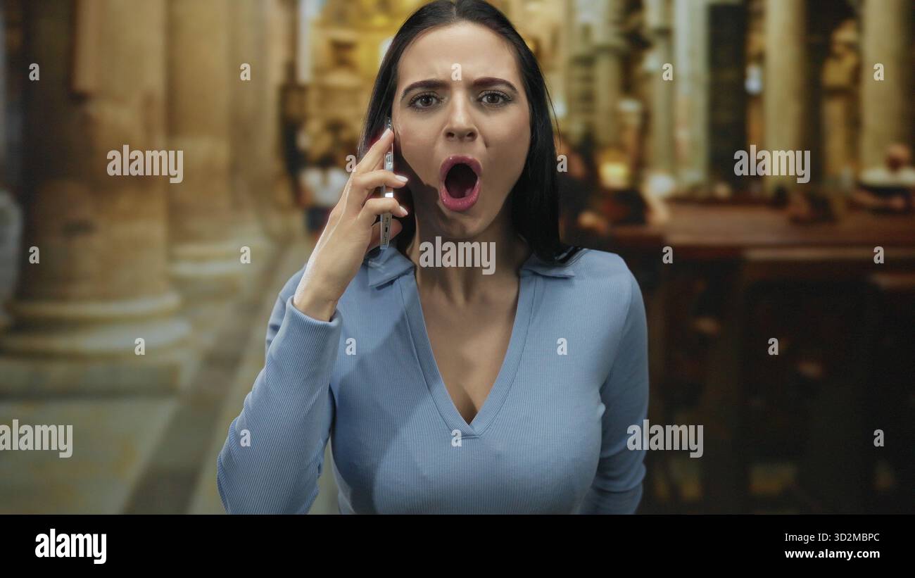Woman talking on smartphone in a church setting expresses emotions ...