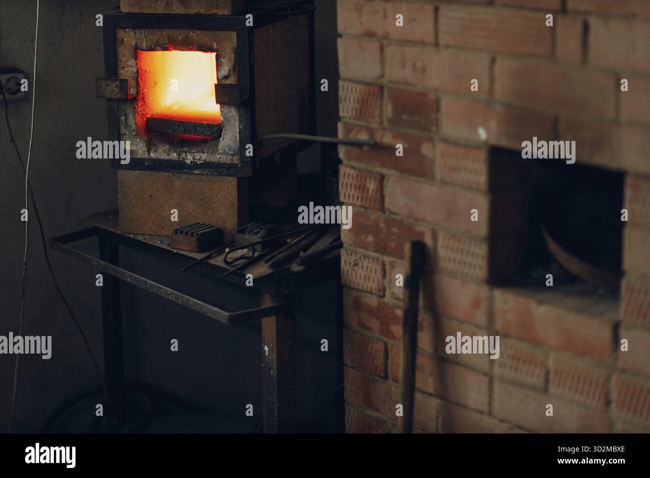 Blacksmith forge oven with hot flame. Smith heating iron piece of steel ...