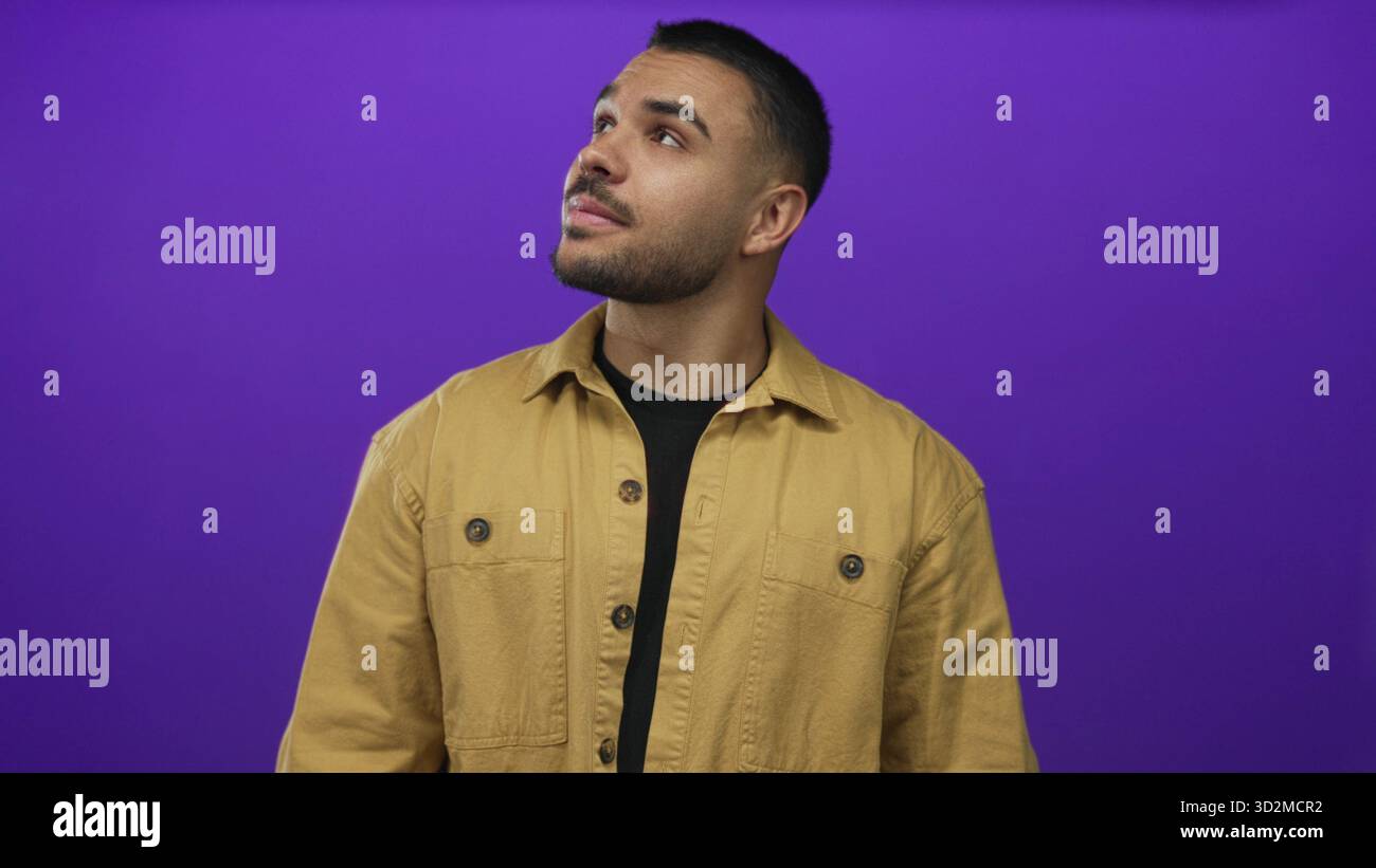 Man face looking up in purple studio setting wearing brown jacket with ...