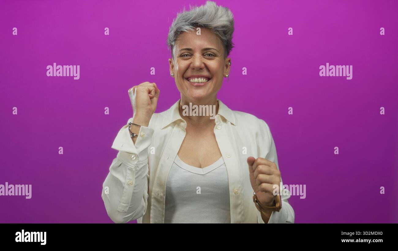 Short haired woman in white shirt clapping and smiling in a purple ...