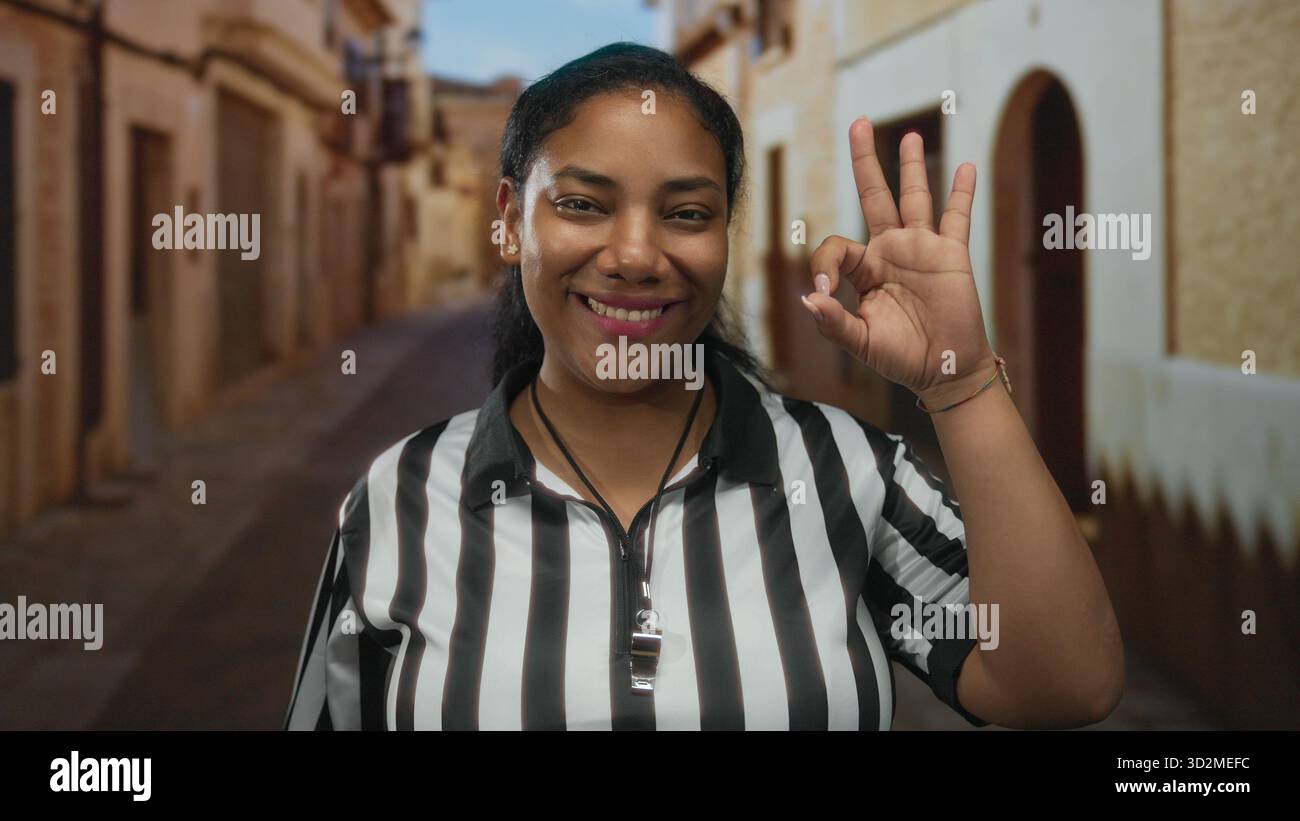Referee woman wearing striped uniform and whistle gives ok sign with ...