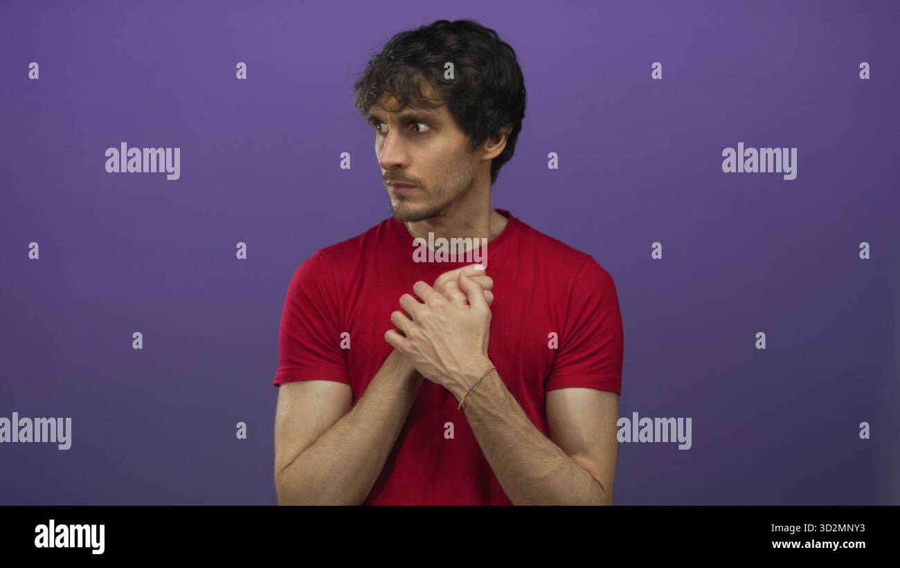 Man with clasped hands clutching chest and anxious gaze in purple ...