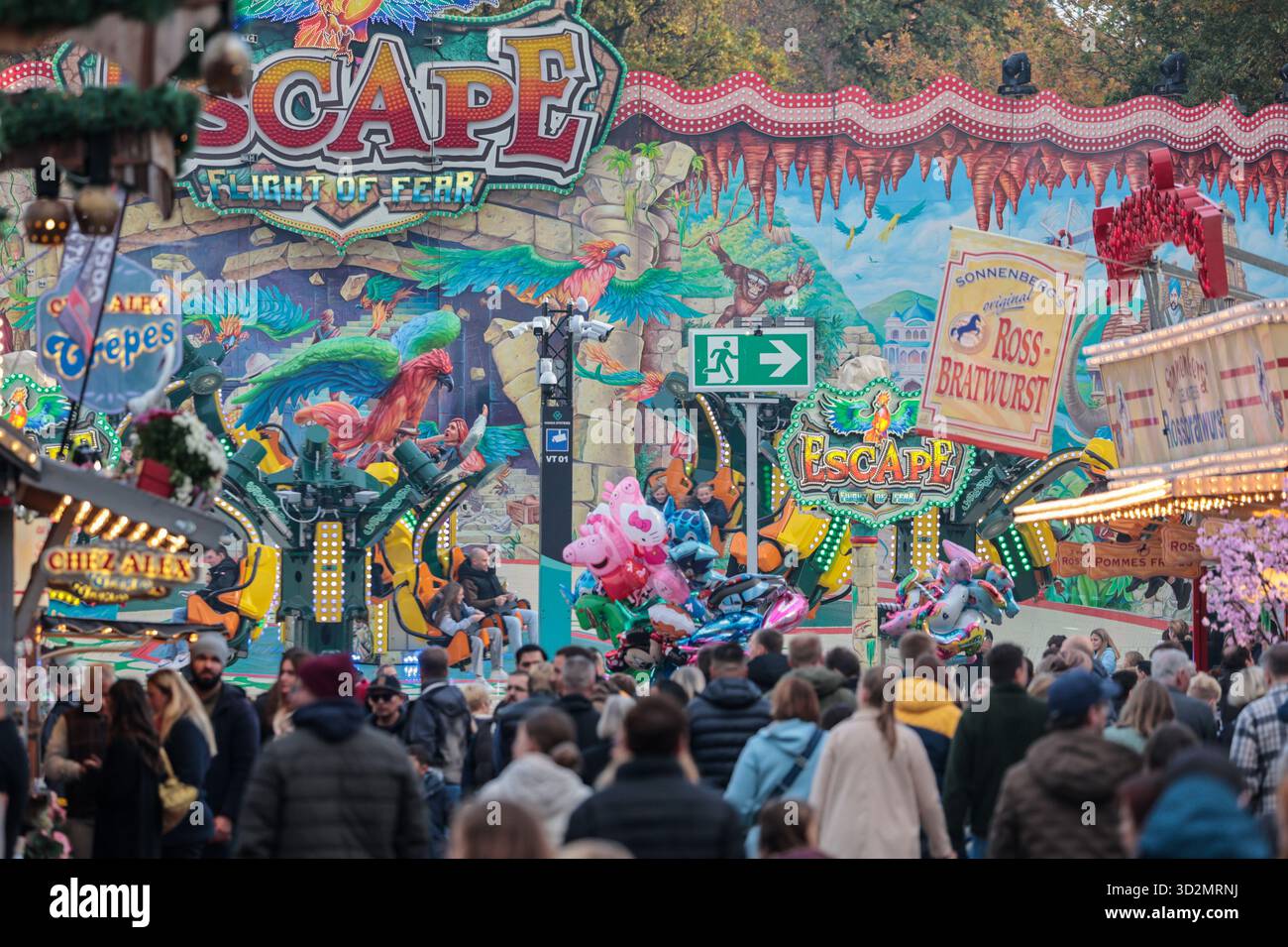 02 November 2025, Bremen: Visitors walk between stalls and fairground ...