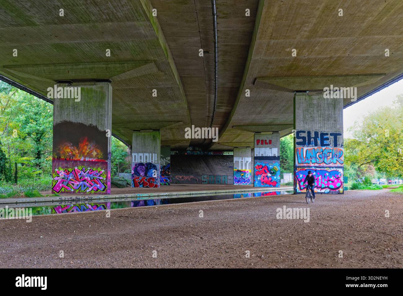 Underneath the large roadway bridge carrying the M25 motorway that ...