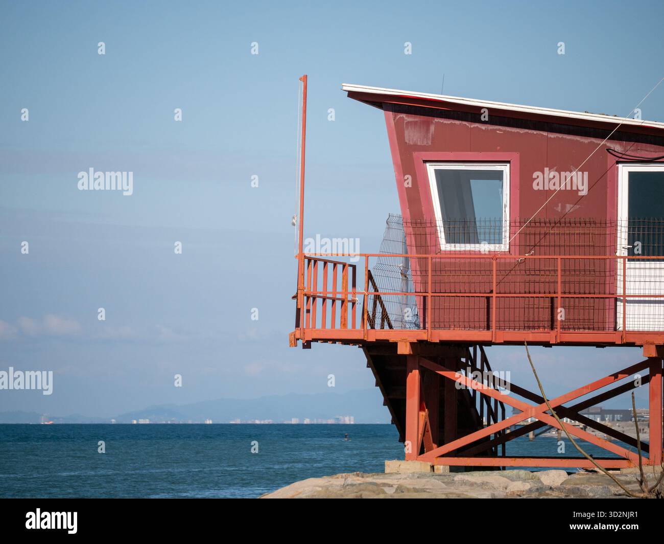 Red lifeguard station on stilts near ocean, beach safety concept ...