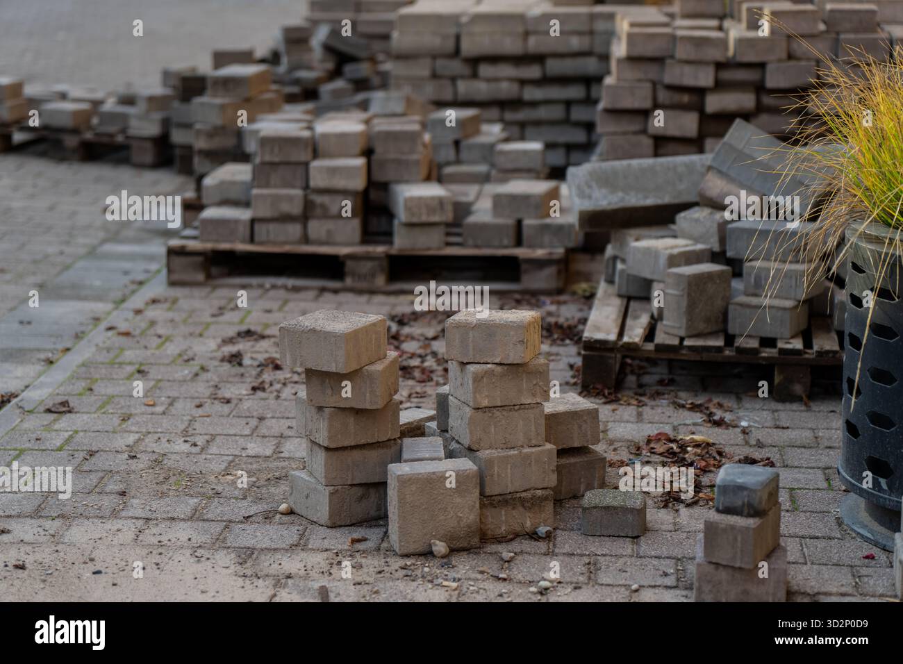 Stack of concrete paving blocks and construction materials on site ...
