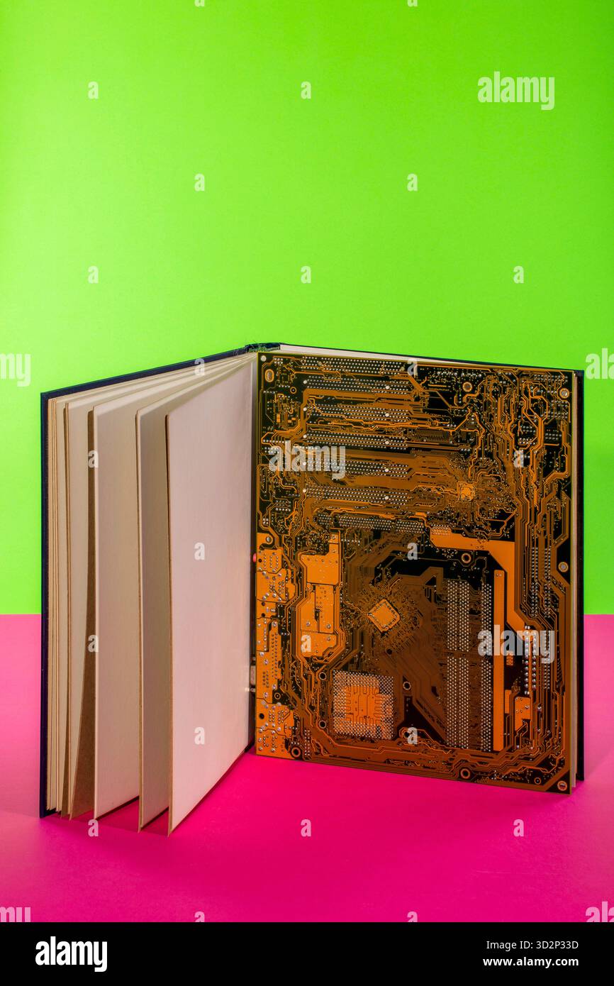 Computer motherboard in a large open book on a colored background Stock ...