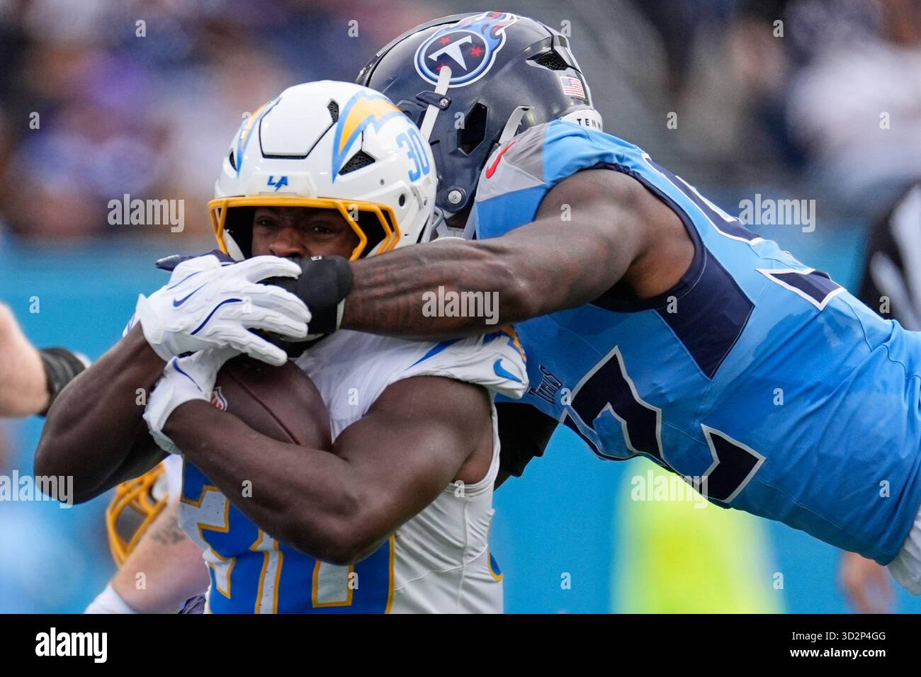 Los Angeles Chargers running back Kimani Vidal (30) is tackled by Tennessee Titans linebacker ...