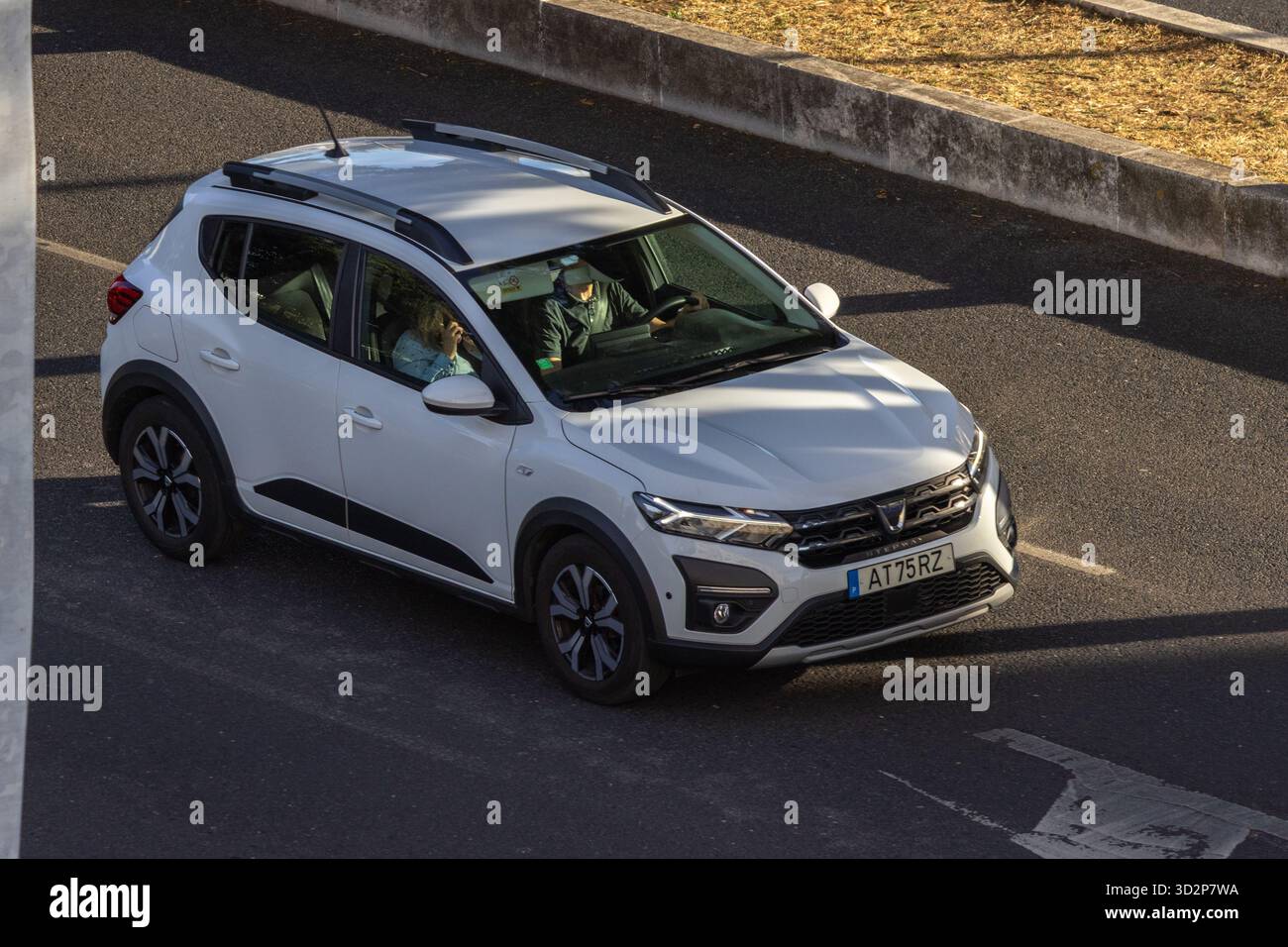White dacia sandero stepway suv driving on a paved road with blurred ...