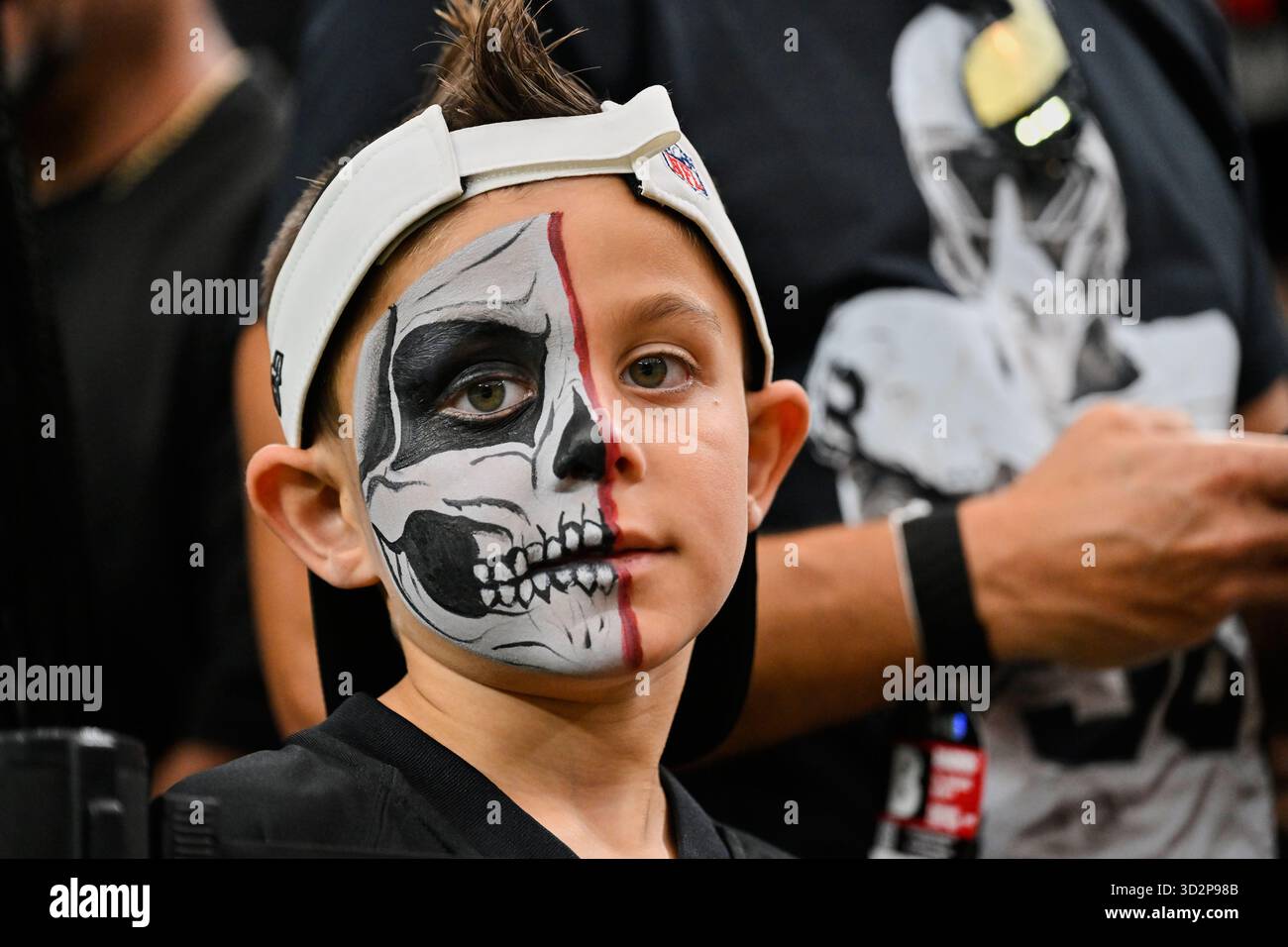 A young fan wears face paint while attending an NFL football game ...
