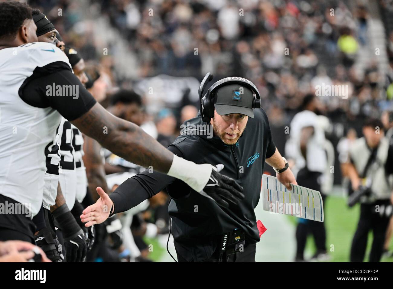 Jacksonville Jaguars head coach Liam Coen, right, shakes hands with ...