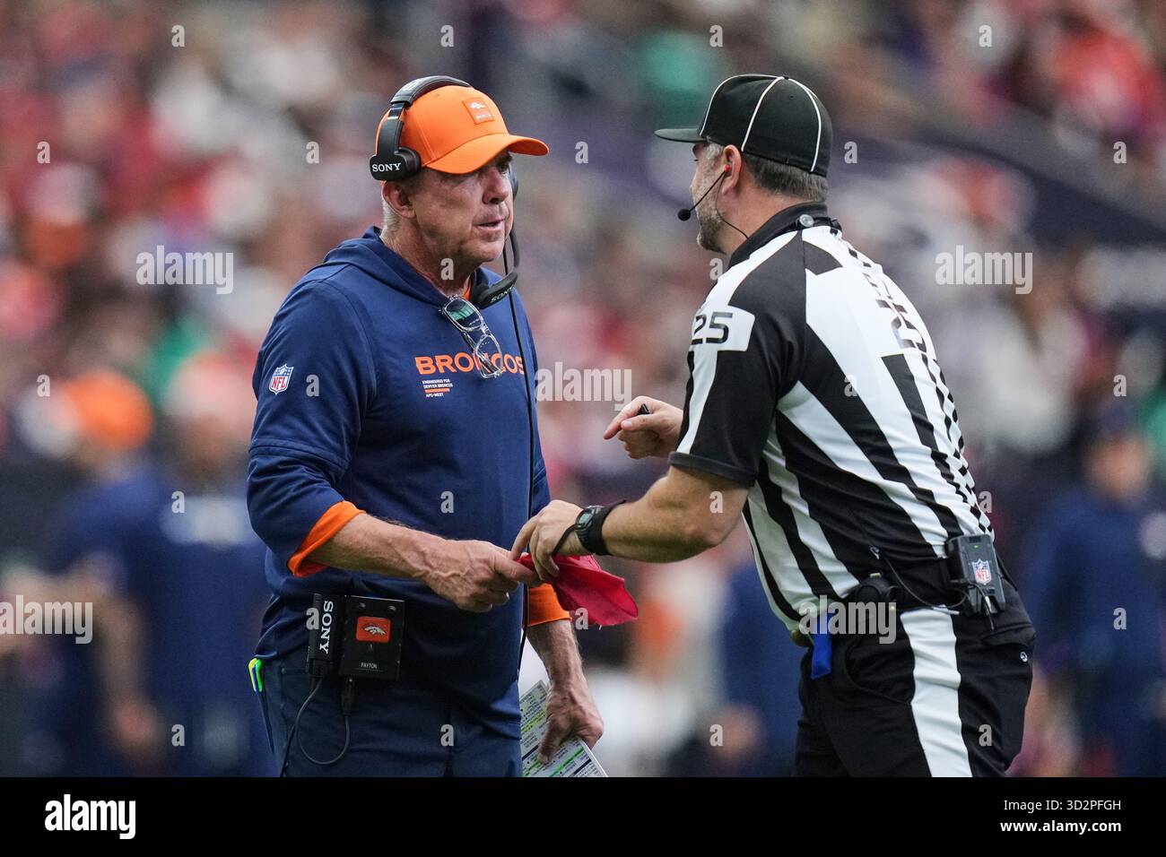 Denver Broncos head coach Sean Payton holds the challenge flag as he talks with field judge Ryan ...
