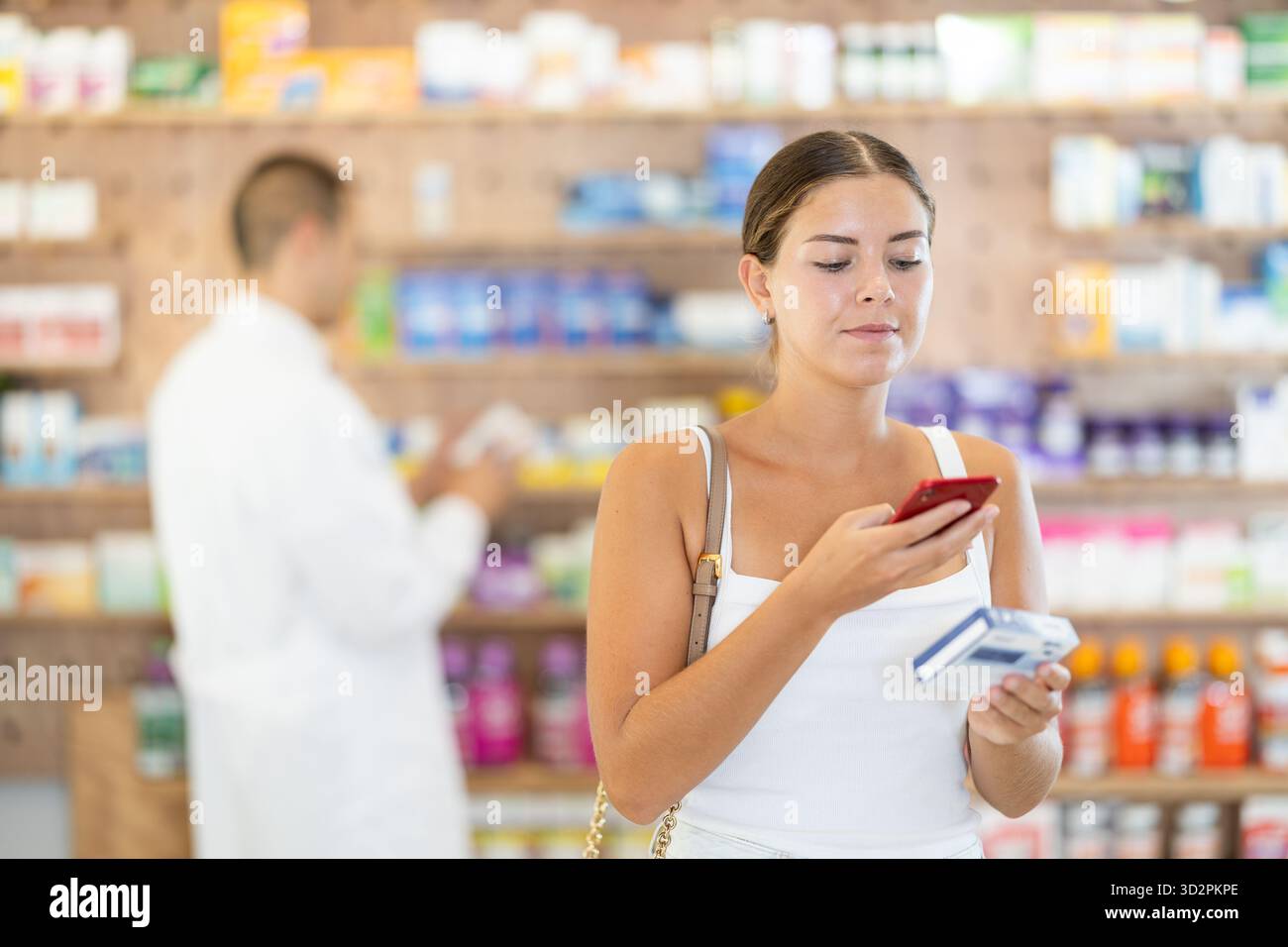 In pharmacy girl customer scans QR code on label box, photographs ...