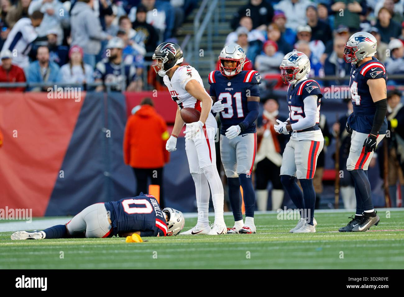 New England Patriots cornerback Christian Gonzalez (0) lies on the turf ...