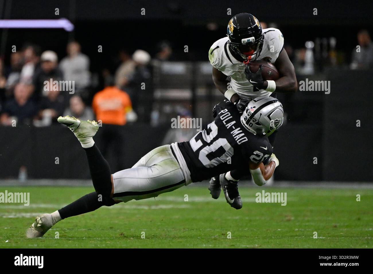 Jacksonville Jaguars running back Travis Etienne Jr. (1) is tackled by Las Vegas Raiders safety ...