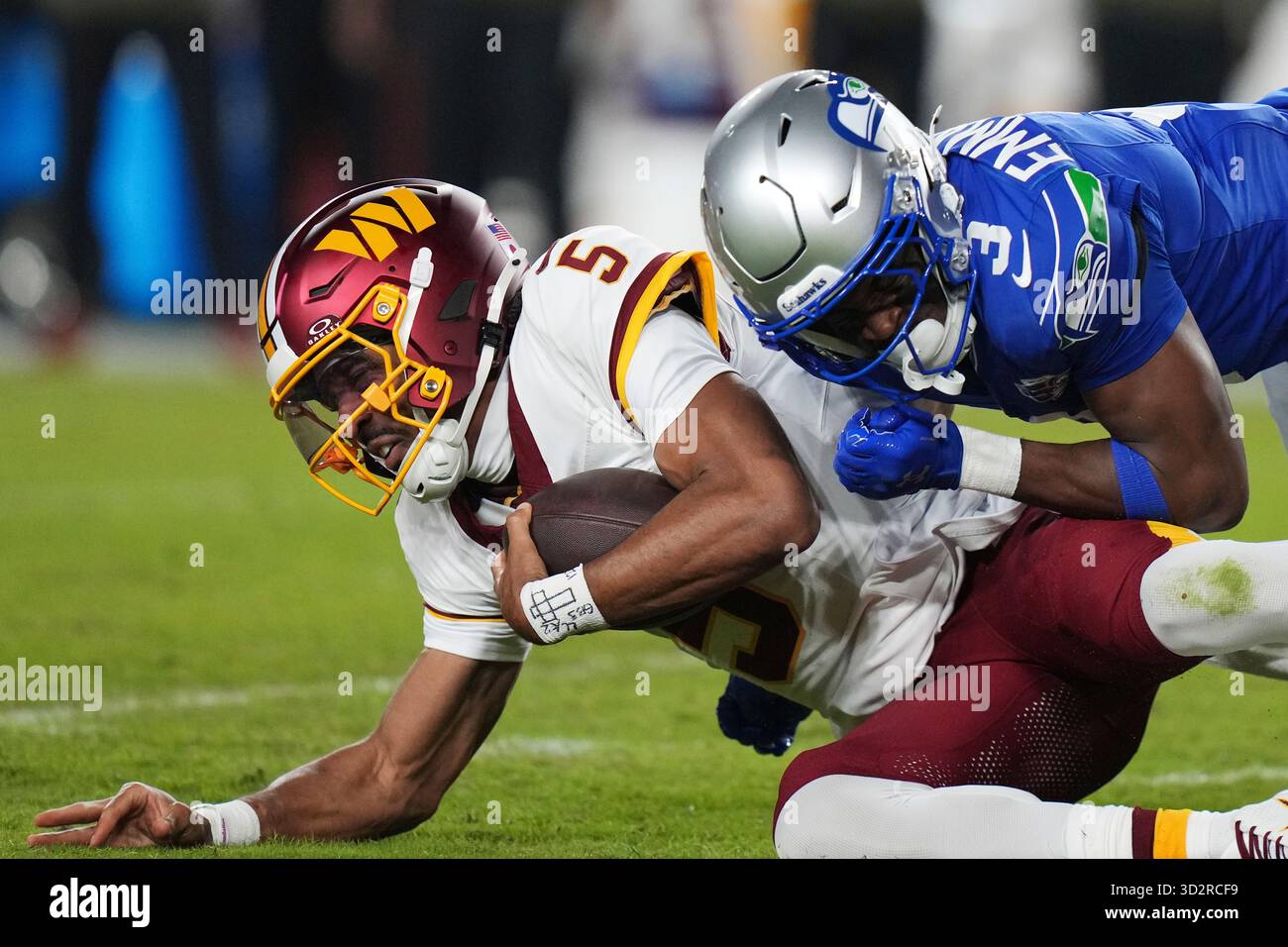 Washington Commanders quarterback Jayden Daniels (5) is tackled by ...
