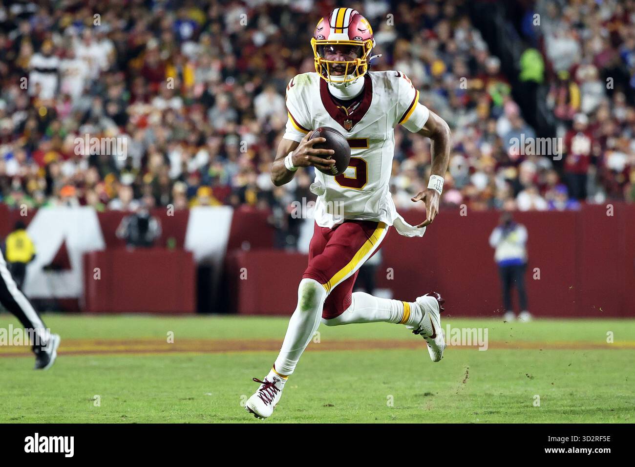 Washington Commanders quarterback Jayden Daniels (5) runs with the ball ...