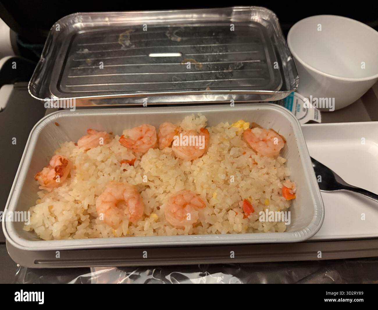Shrimp fried rice, an airline meal, served in a disposable tray on an ...
