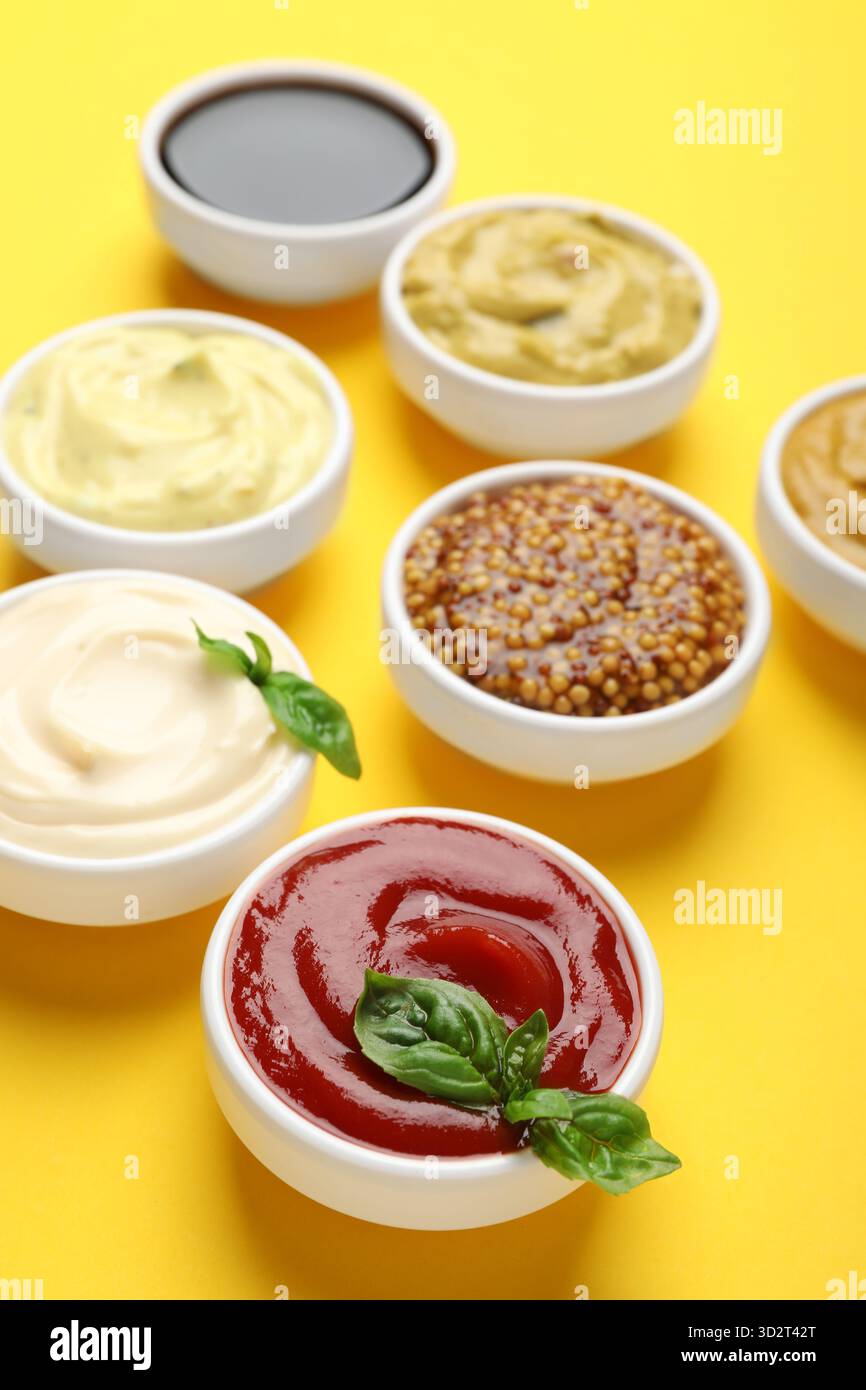 Different sauces and herbs on yellow background, closeup Stock Photo ...