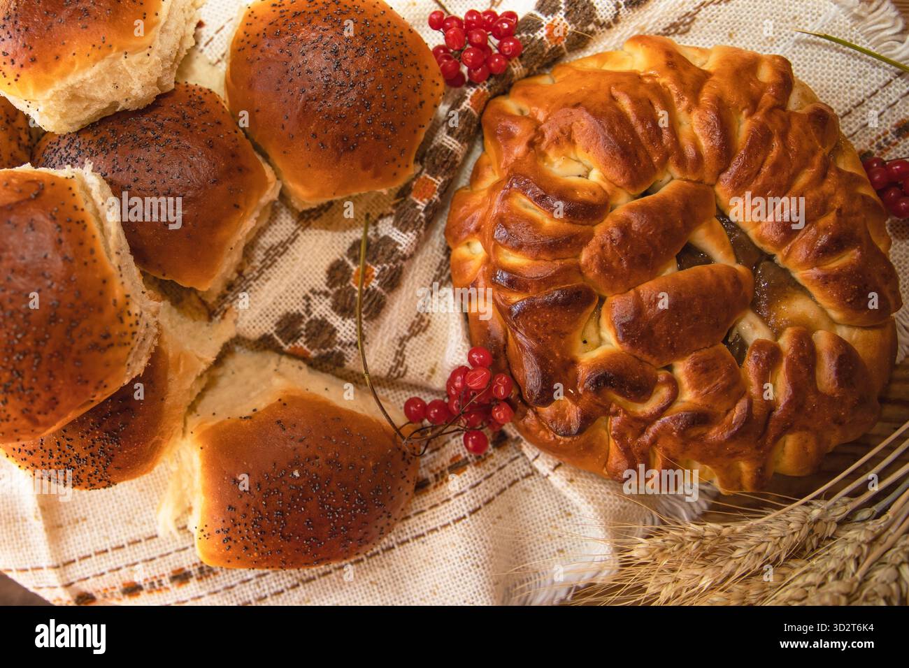 Fresh homemade buns and pie with wheat ears on rustic fabric Stock ...
