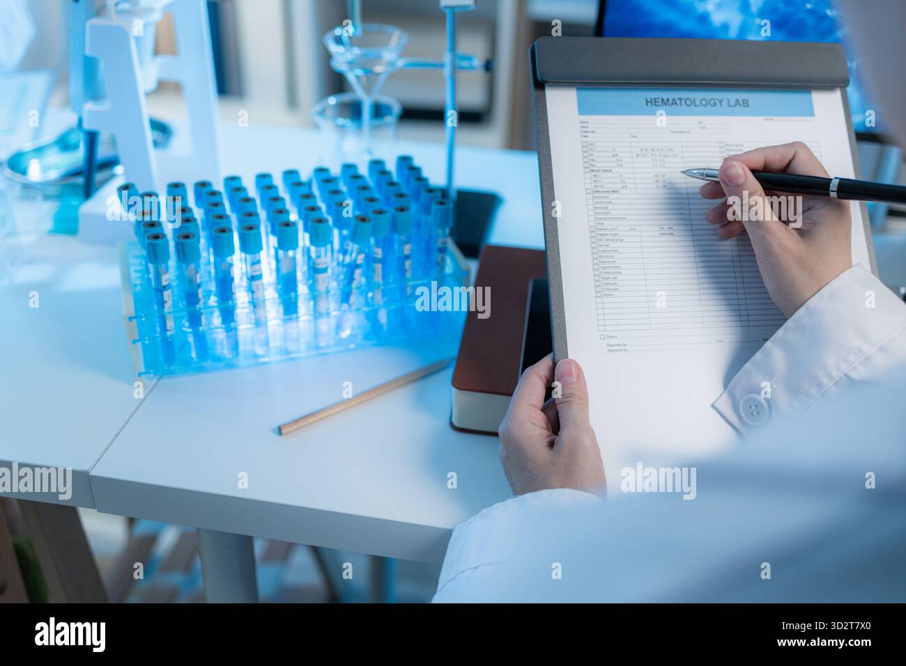 A close-up view of a scientist reviewing hematology lab data on a ...