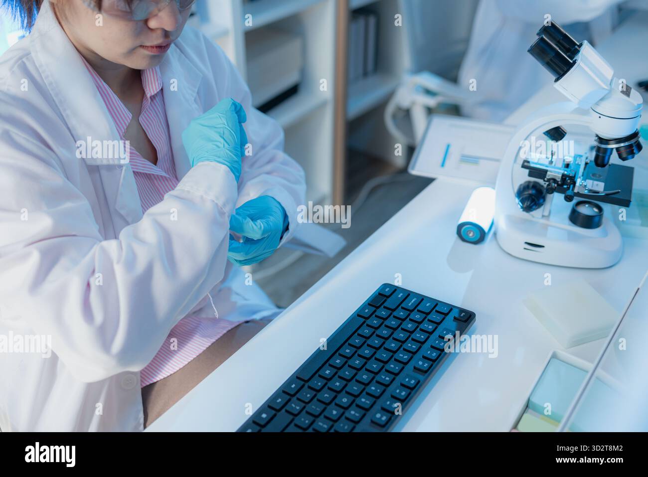 A chemistry researcher in a laboratory surrounded by scientific ...