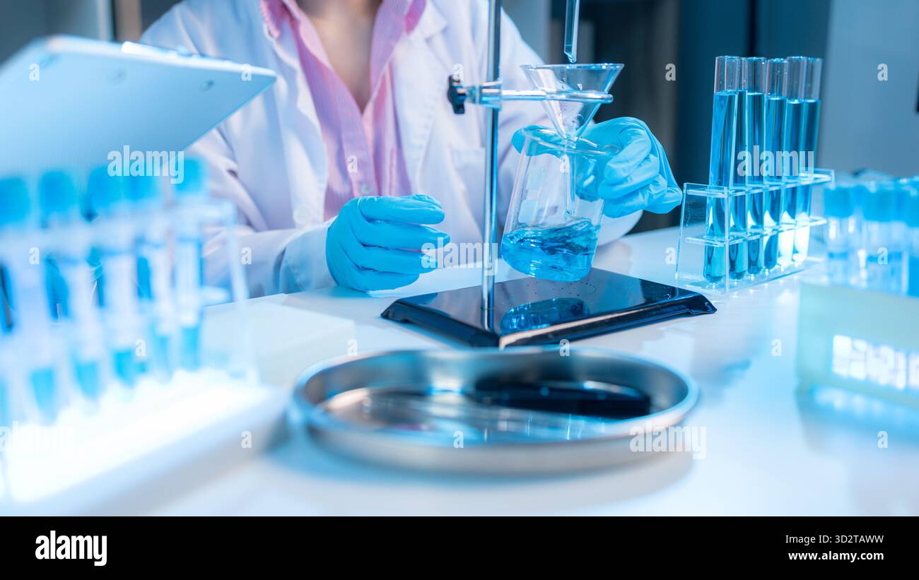 Two chemists in white lab coats working together in a modern laboratory ...