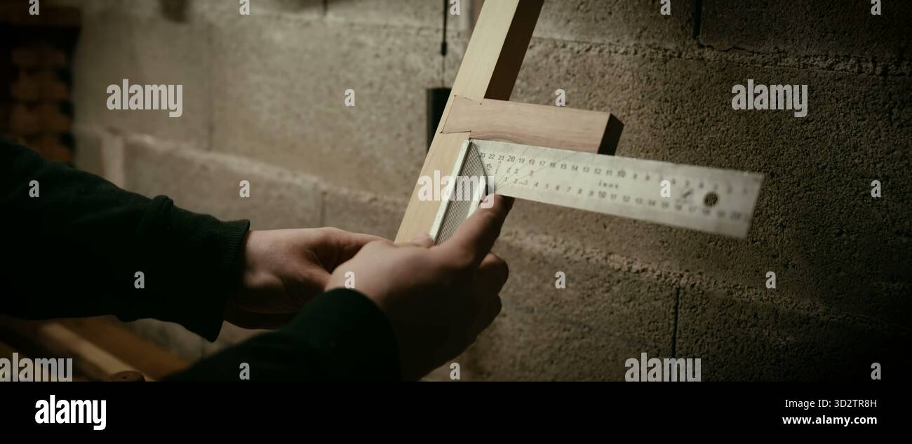 Metal square ruler checks precise angle between joined wood pieces ...