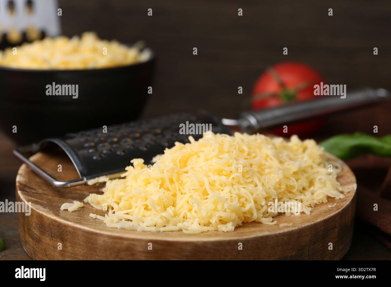 Grated cheese, grater, tomato and basil on table, closeup Stock Photo ...