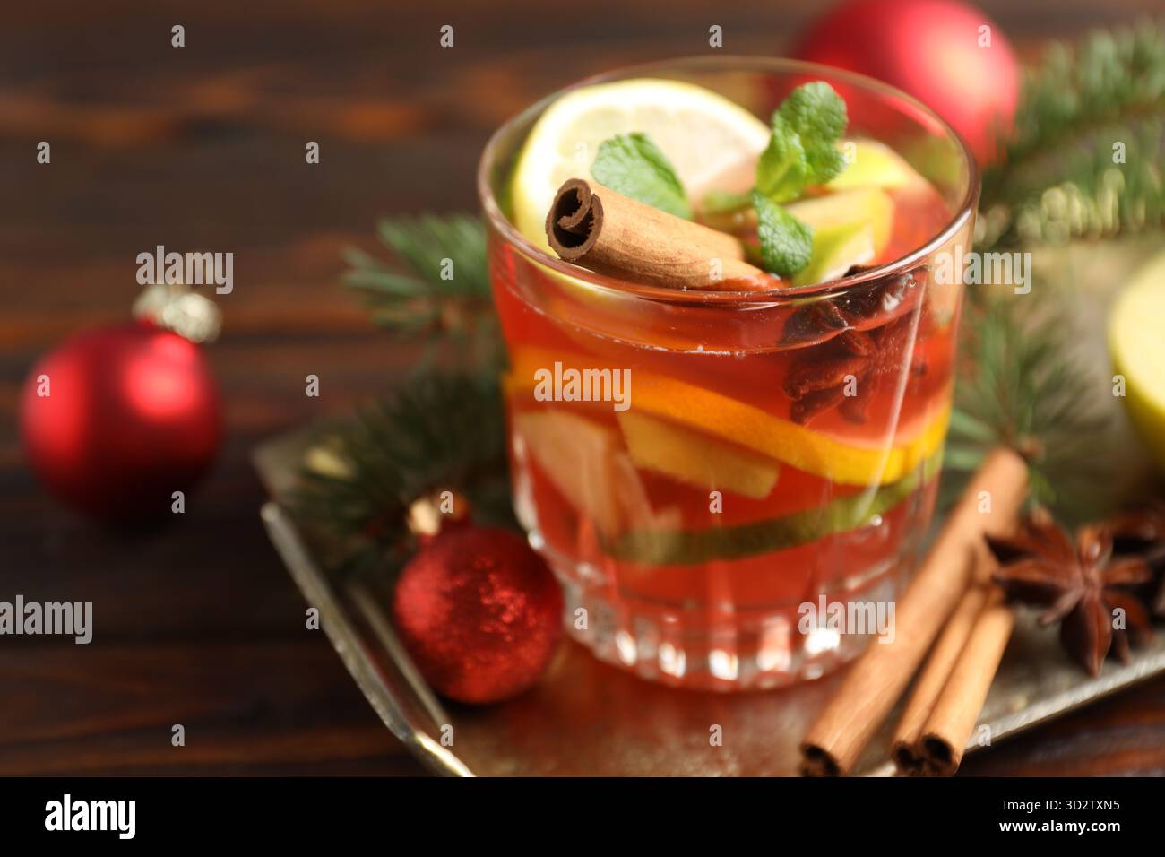 Tasty punch drink, spices and Christmas decor on wooden table, closeup ...