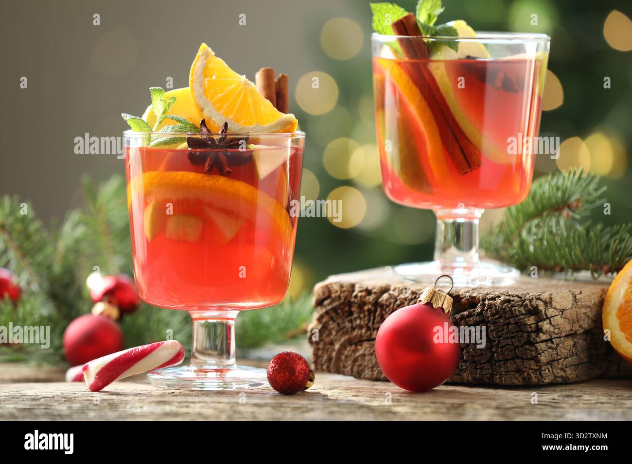 Tasty punch drink in glasses, spices and Christmas decor on wooden ...