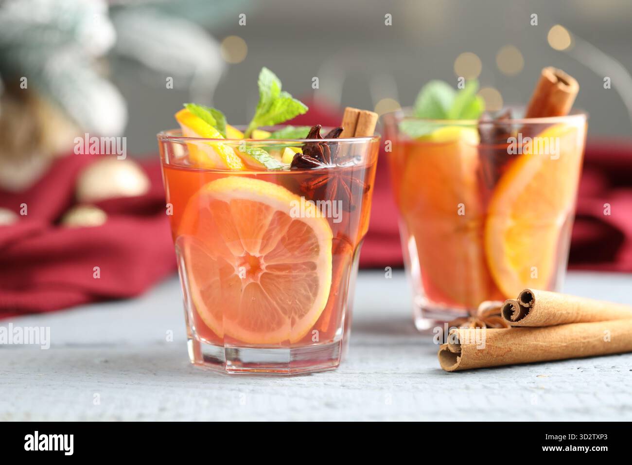 Tasty punch drink in glasses and spices on white wooden table against ...