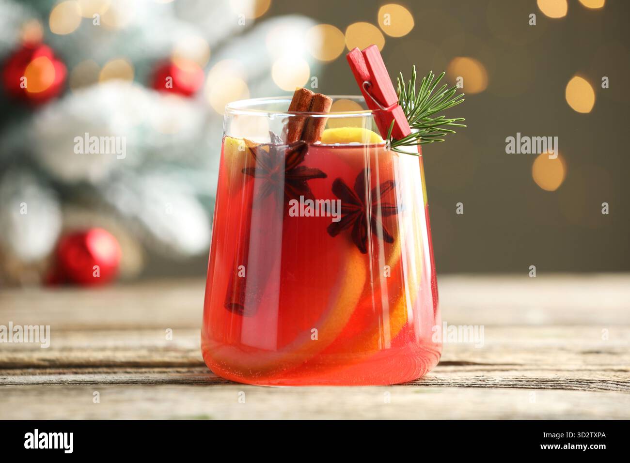 Tasty punch drink in glass, spices and Christmas decor on wooden table ...