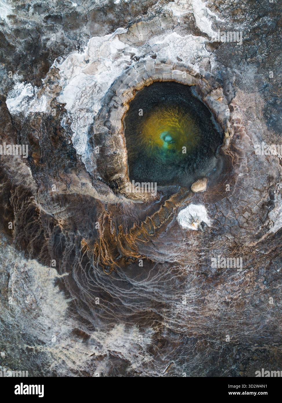 Aerial view of a geothermal spring with swirling turquoise waters ...