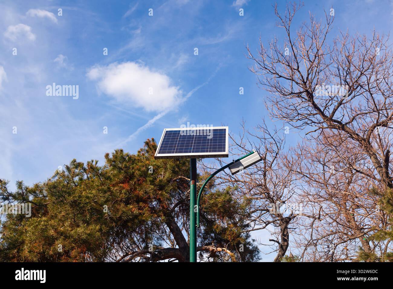 A solar panel is installed on a street lamp post in a park Stock Photo ...