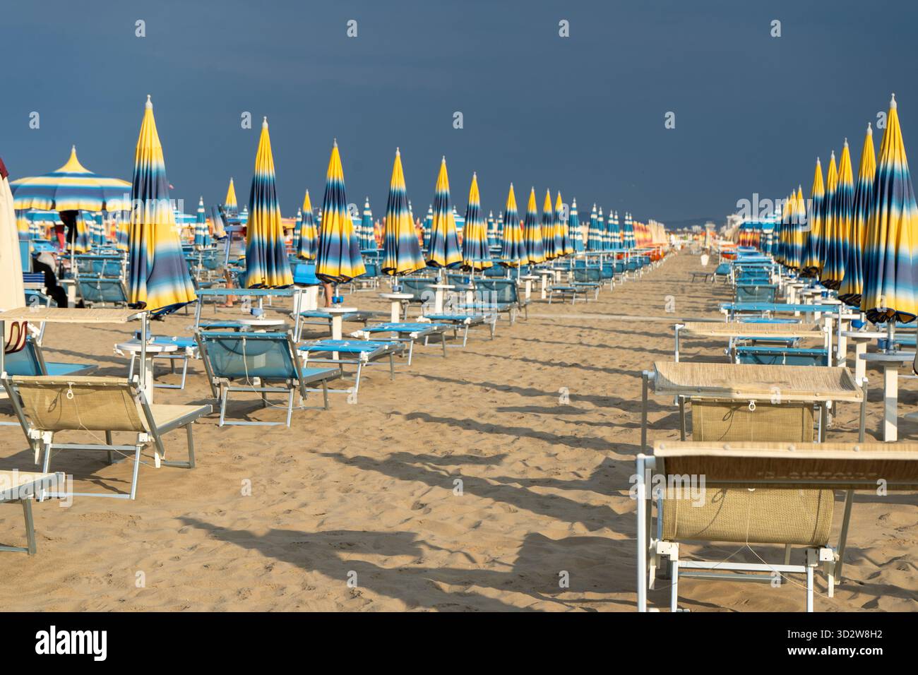 Sun loungers on long sandy beach with Umbrellas. Empty seaside resort ...