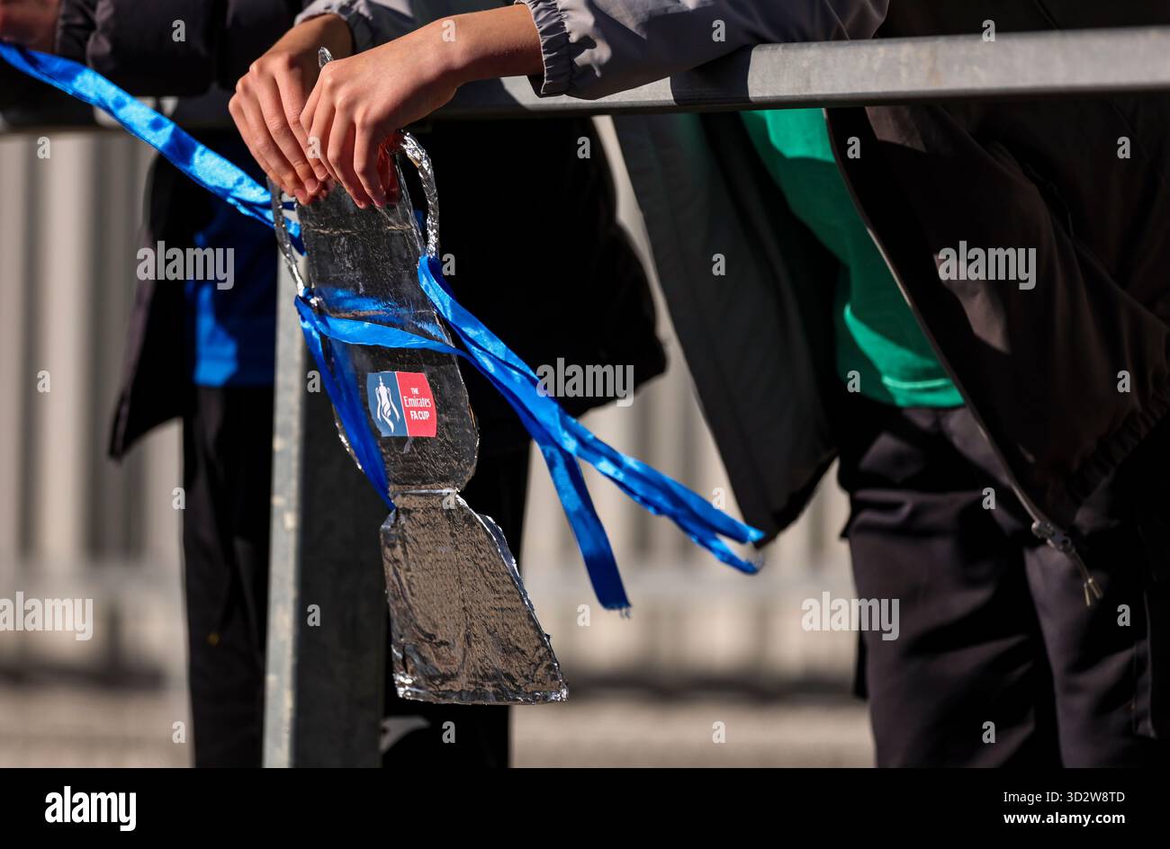 A fan holding a tin foil FA Cup trophy before the Emirates FA Cup first ...