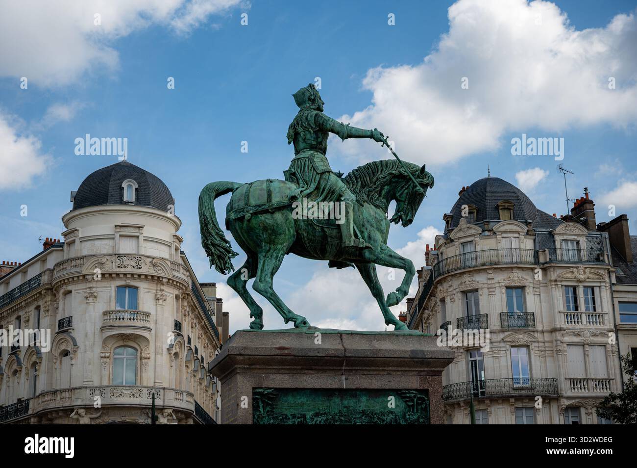 Bronze statue of Joan of Arc prominently framed between two historic ...