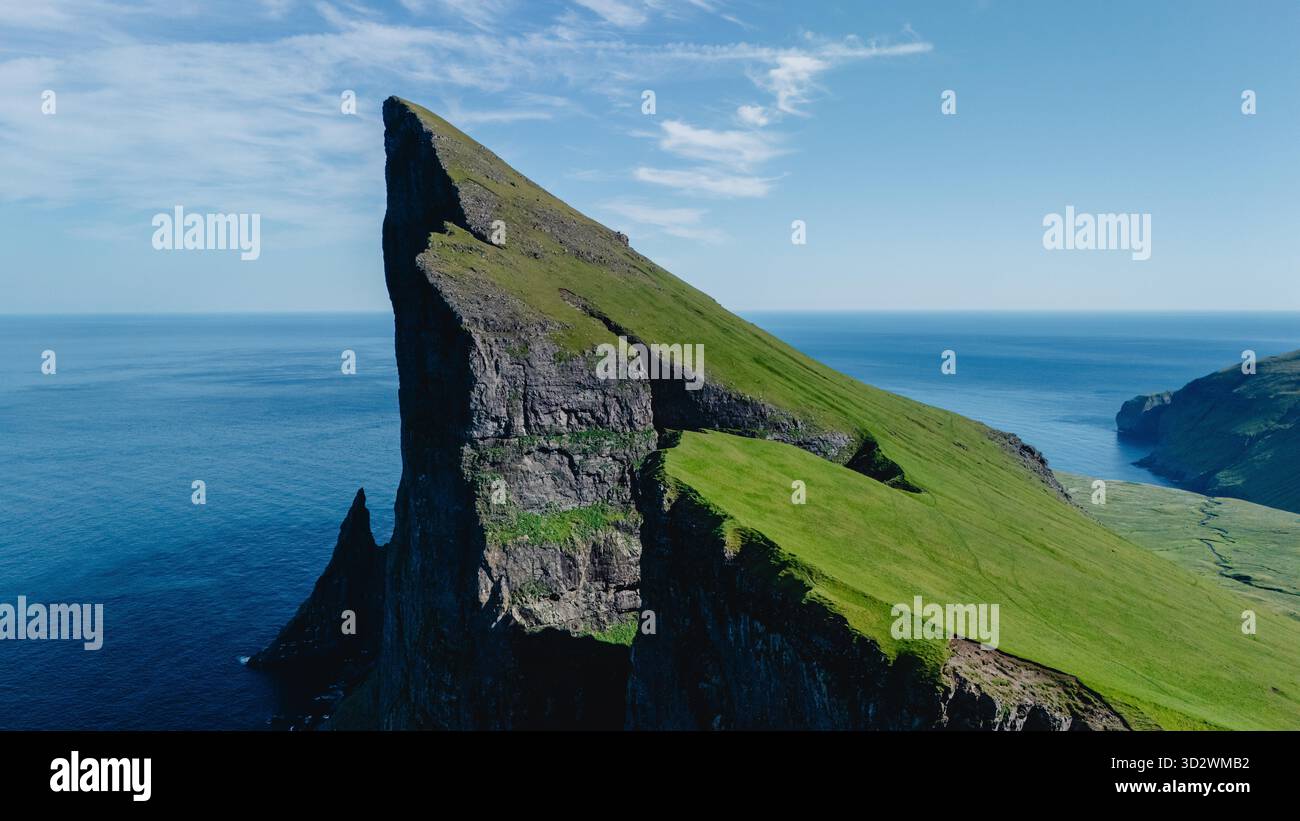Stunning view of a dramatic cliff rising sharply from lush green ...