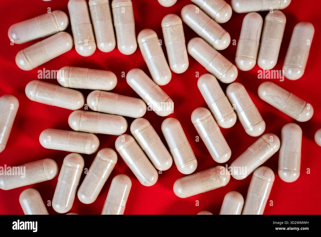 Macro close-up of capsules scattered on red surface. Modern ...