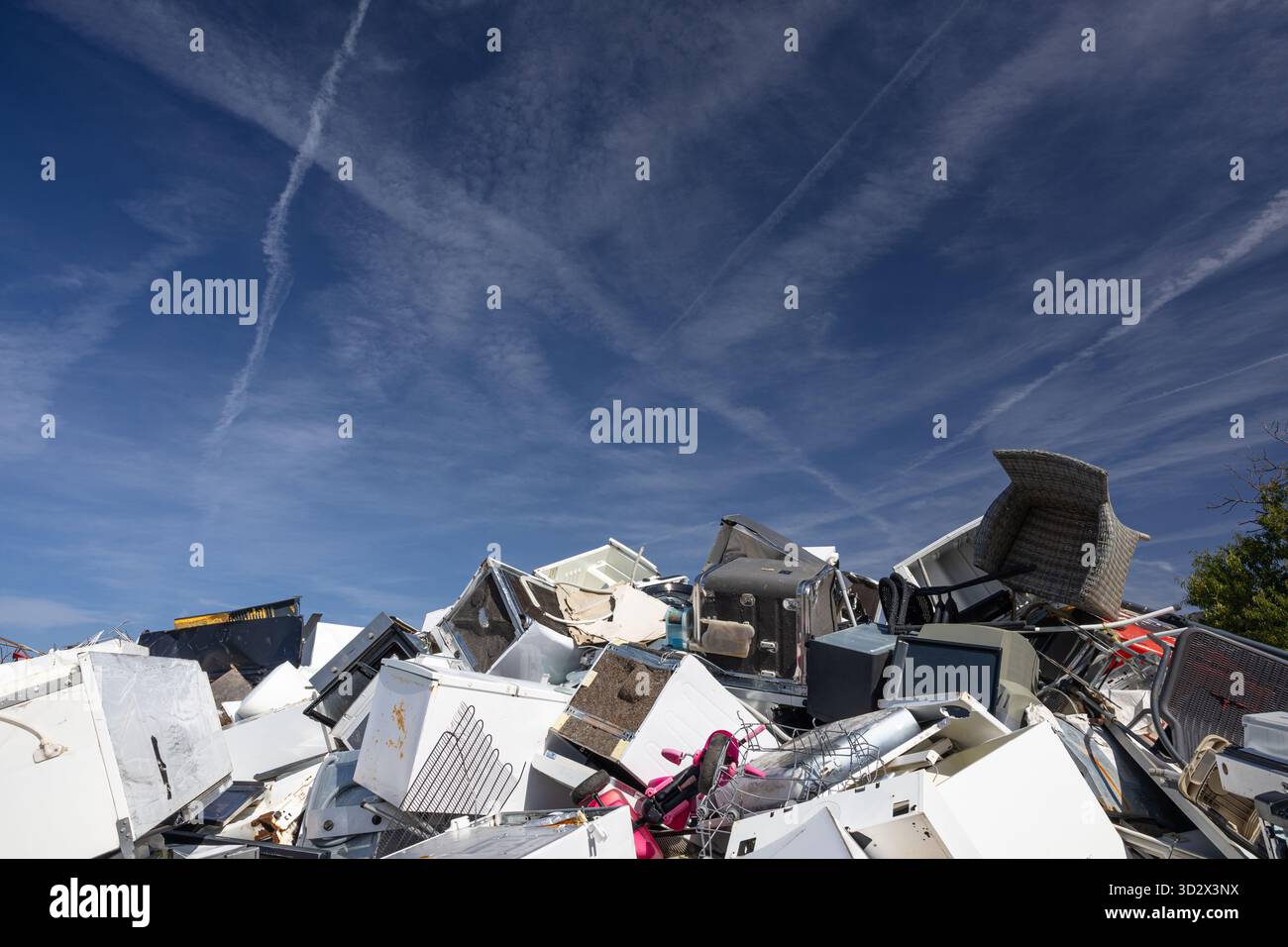 A vast heap of discarded appliances, furniture, and metal clutter lies ...