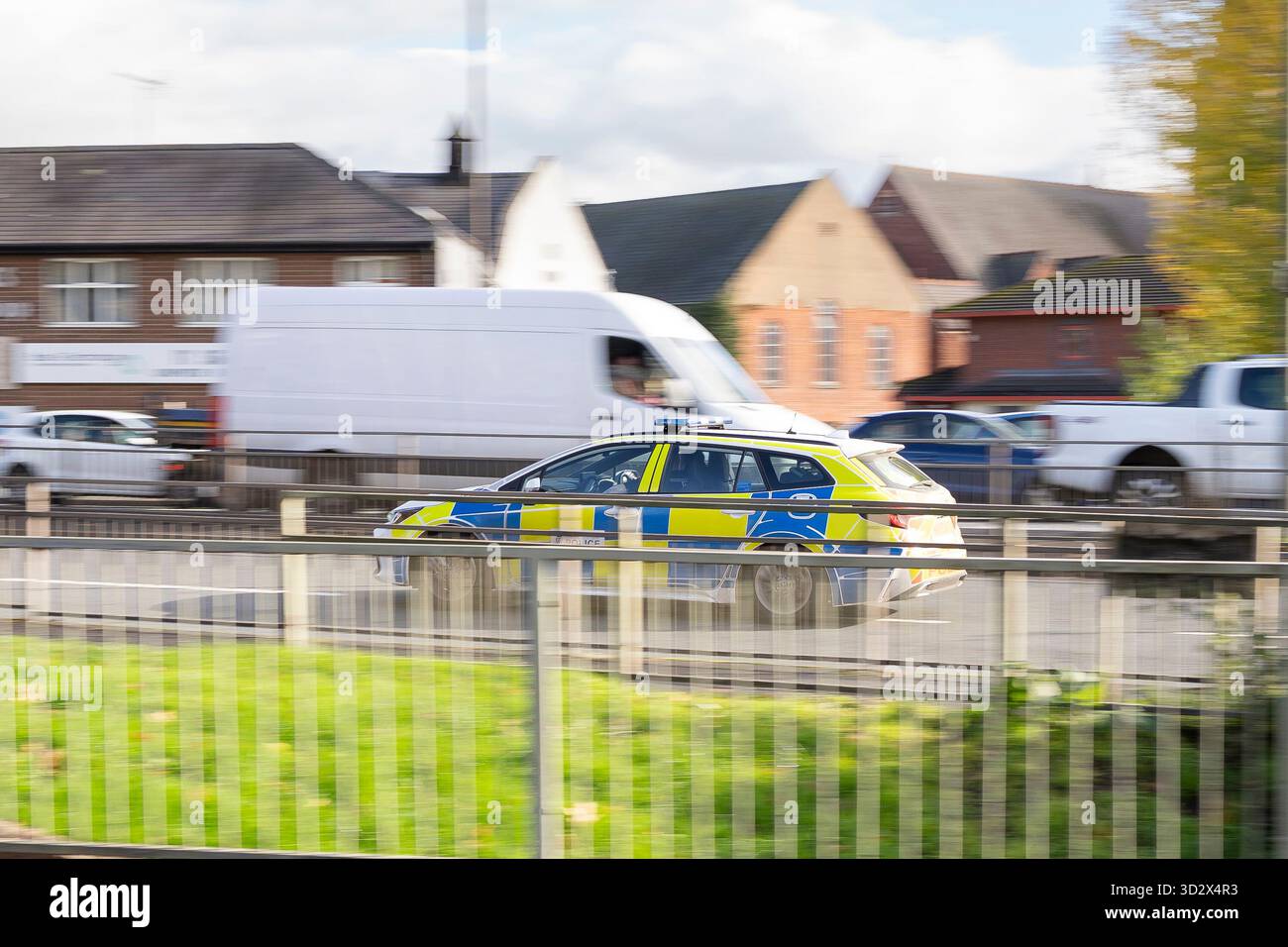 Side view of a UK police car rushing to an emergency, through traffic ...